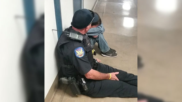 Police officer sits on floor to comfort crying middle school student ...